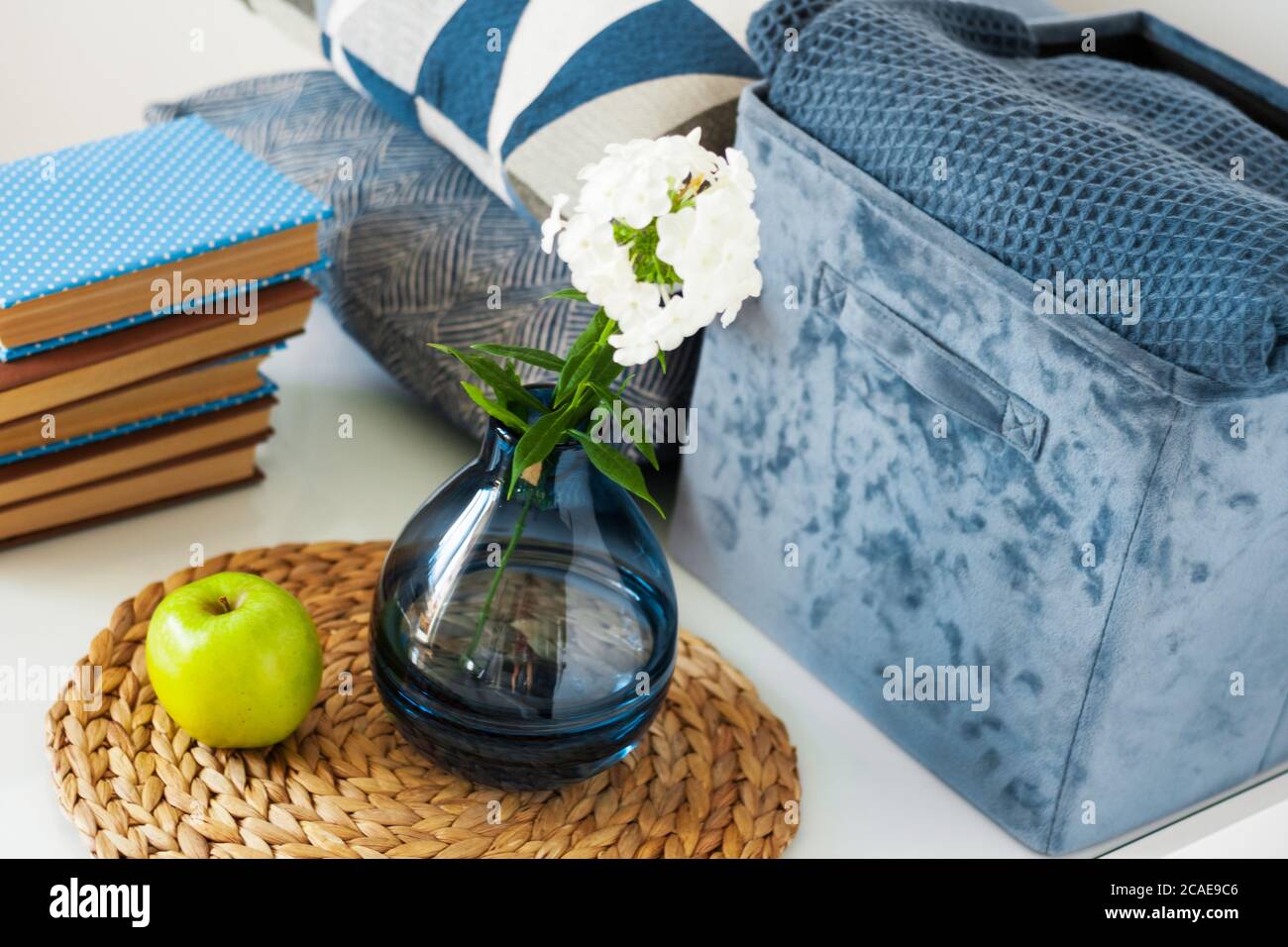 Cozy home interior decor: stack of books, green apple, decorative ...