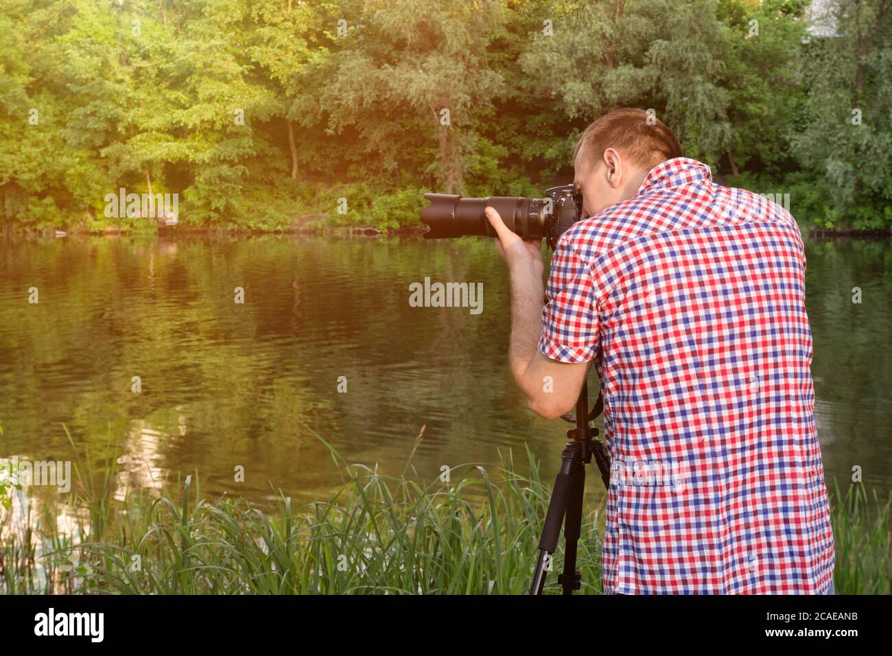 Photographer is shooting on the background of the river Stock Photo - Alamy