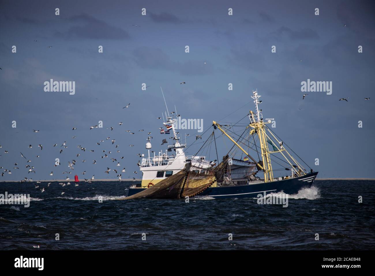 fishing ship with working fishnet Stock Photo - Alamy