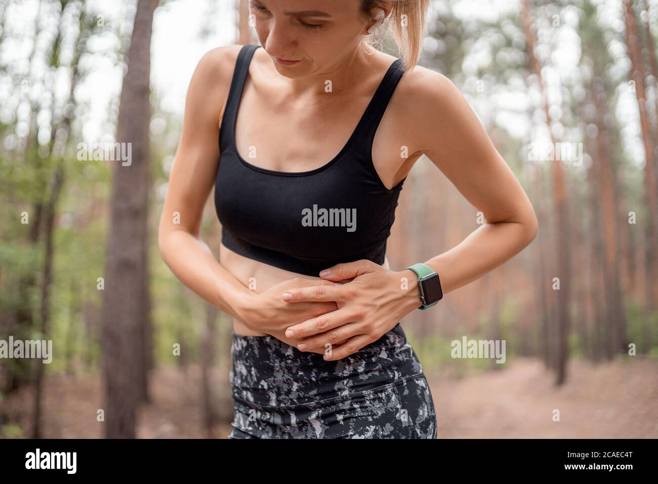 Side stitch woman runner side cramps after running. Jogging woman with ...