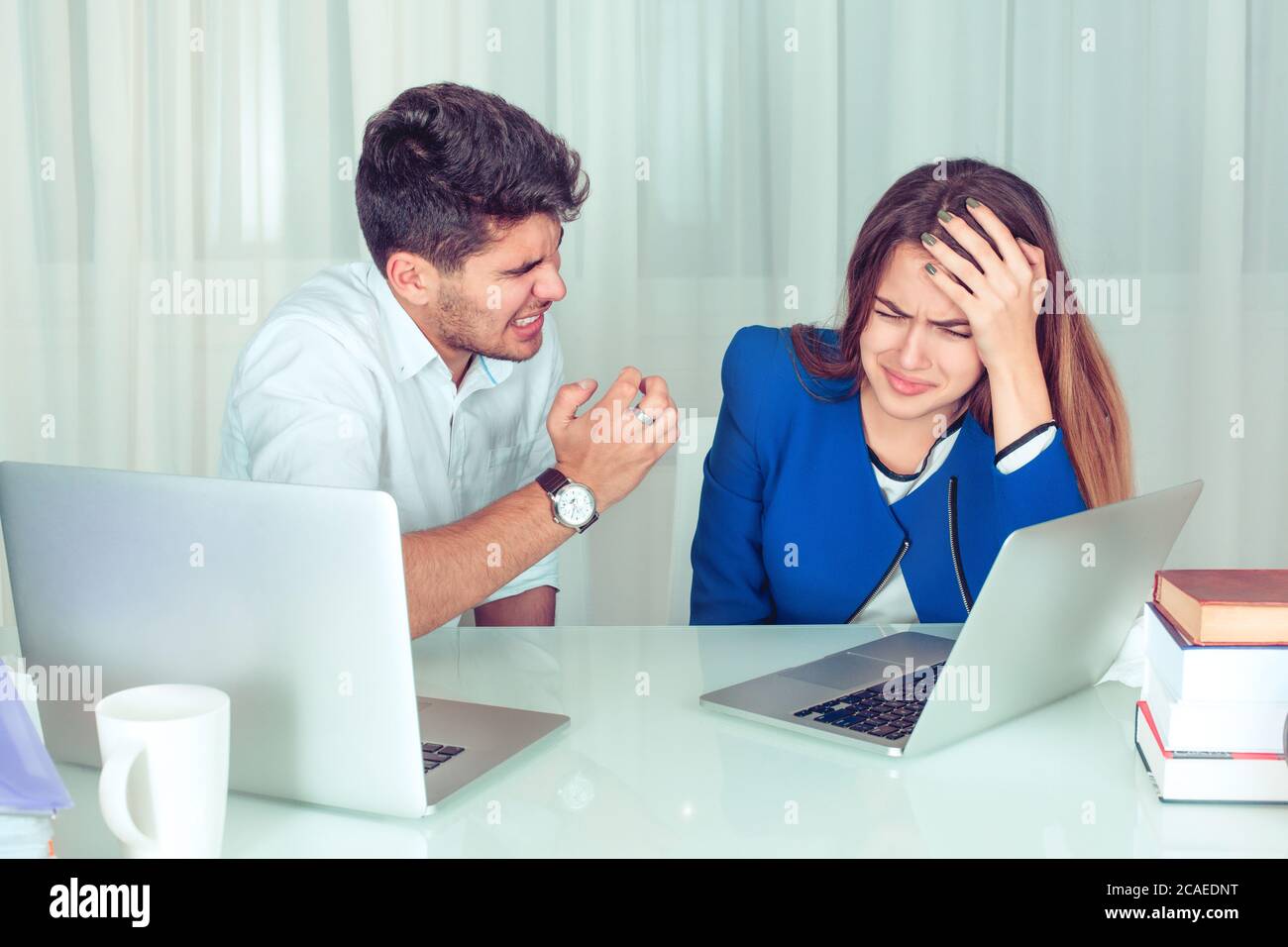 Young Screaming Mad Frustrated Man And Nervous Woman Sitting At
