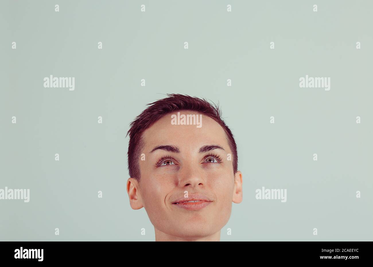 Portrait happy beautiful woman thinking looking up isolated on light ...