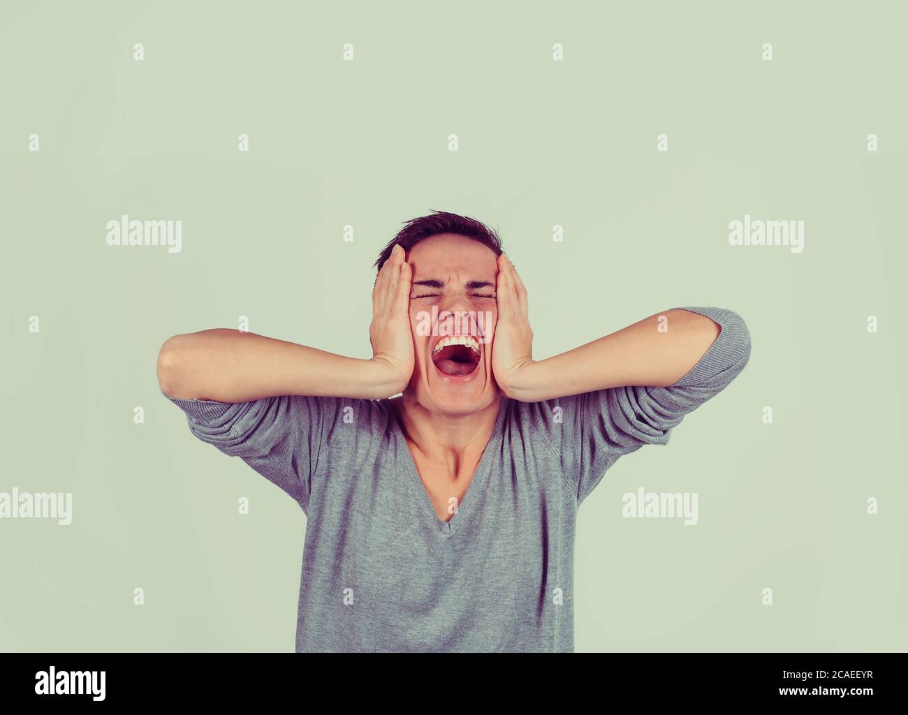 Portrait young unhappy stressed woman hands on head screaming yelling ...