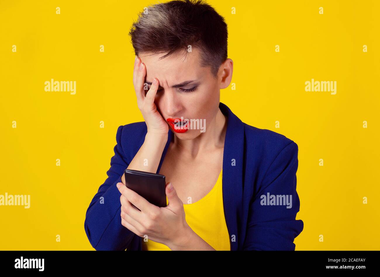 Shocked stunned woman looking at phone; depressed stressed hand on face ...