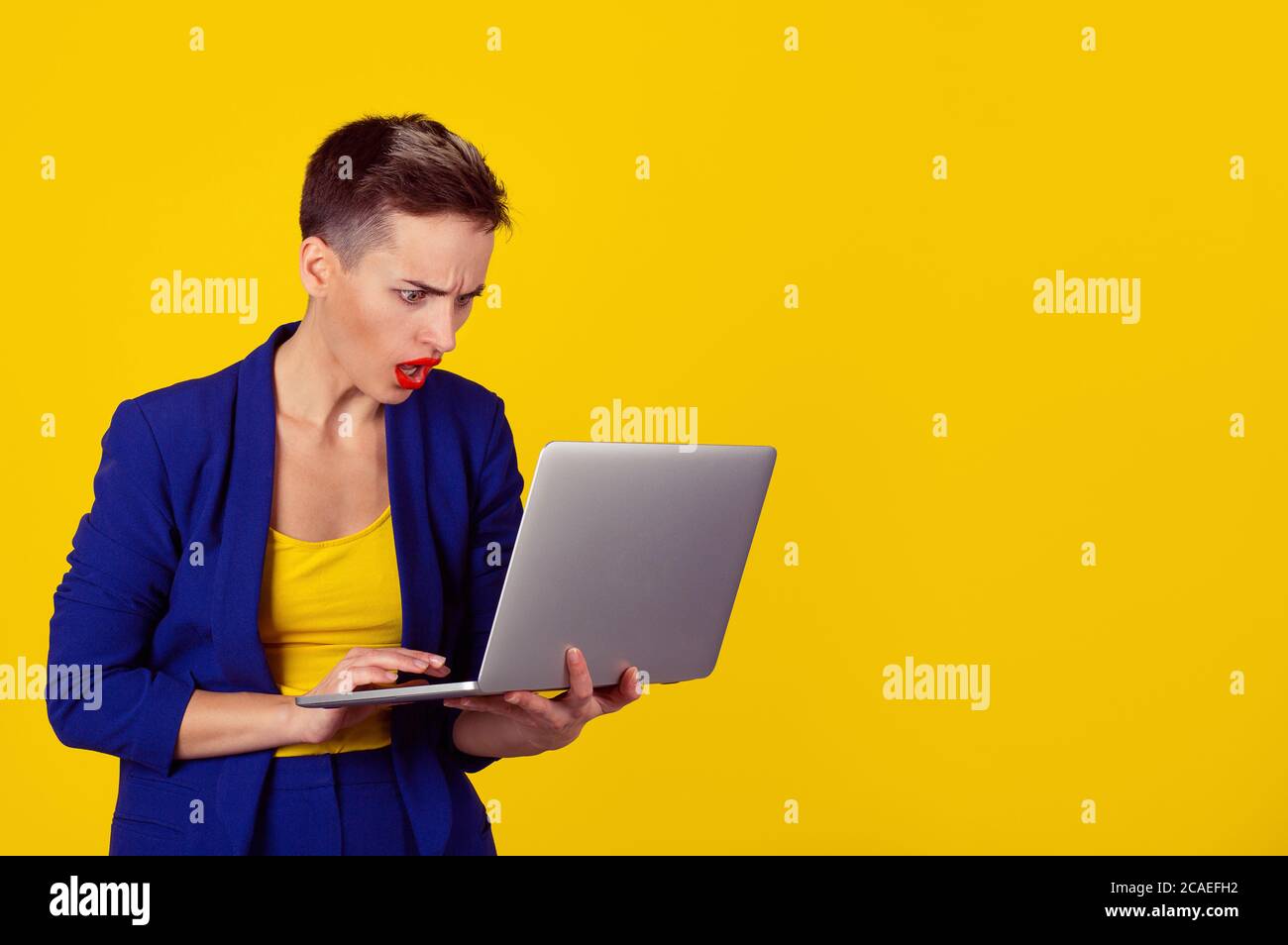 Shocked young business woman using laptop looking at computer screen ...