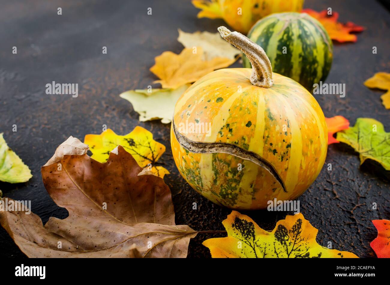 dark Autumn background with pumpkins, yellow leaves Stock Photo - Alamy