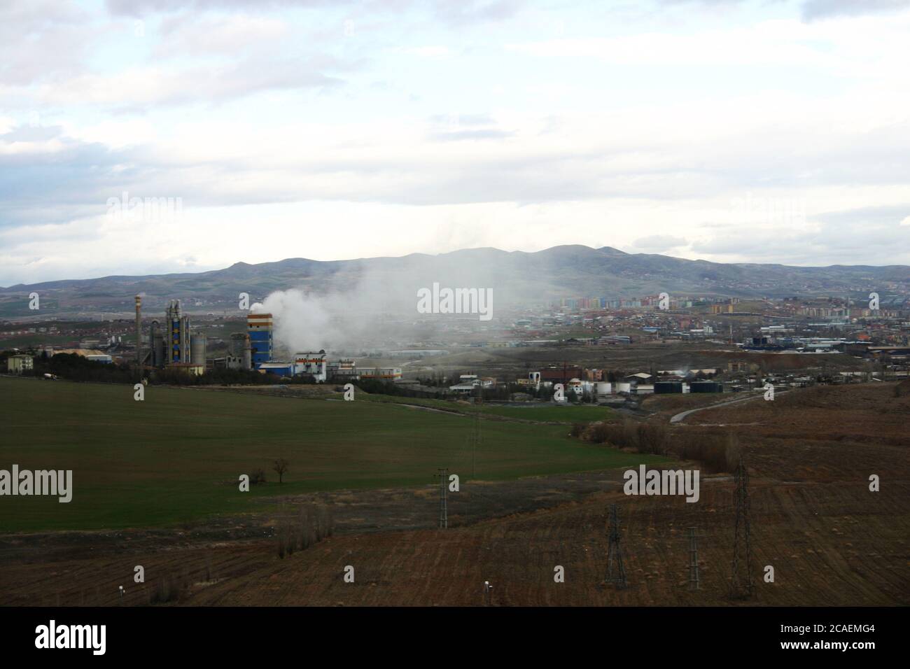 Dirty smoke coming from the chimney of a cement factory in the city and ...