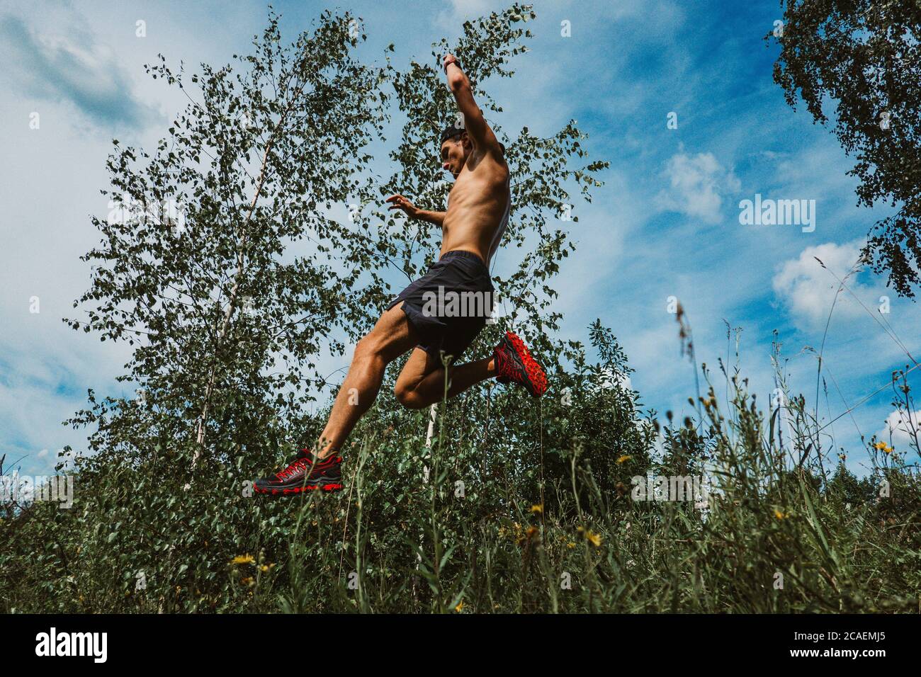Trail runner training outdoors in summer. Run and jump. Trail running ...