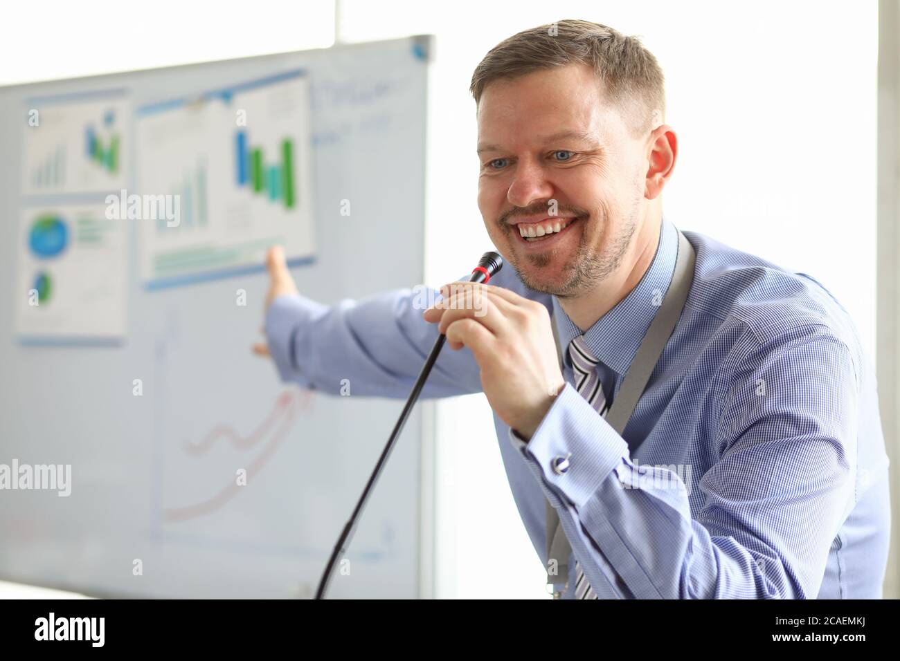 Laughing businessman showing charts and diagrams Stock Photo - Alamy