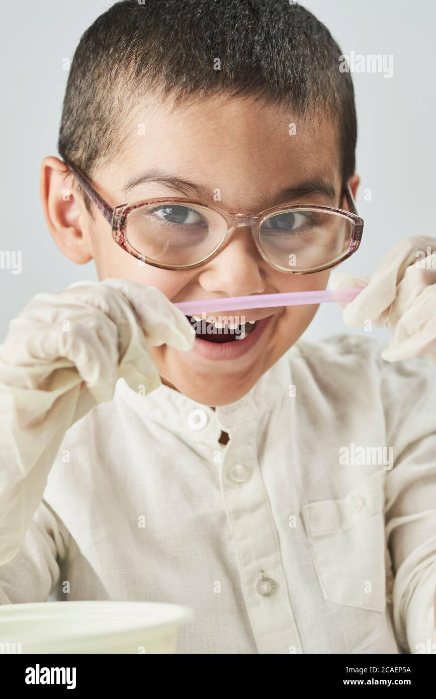 Vertical portrait of a happy schoolboy looking at the camera with funny ...