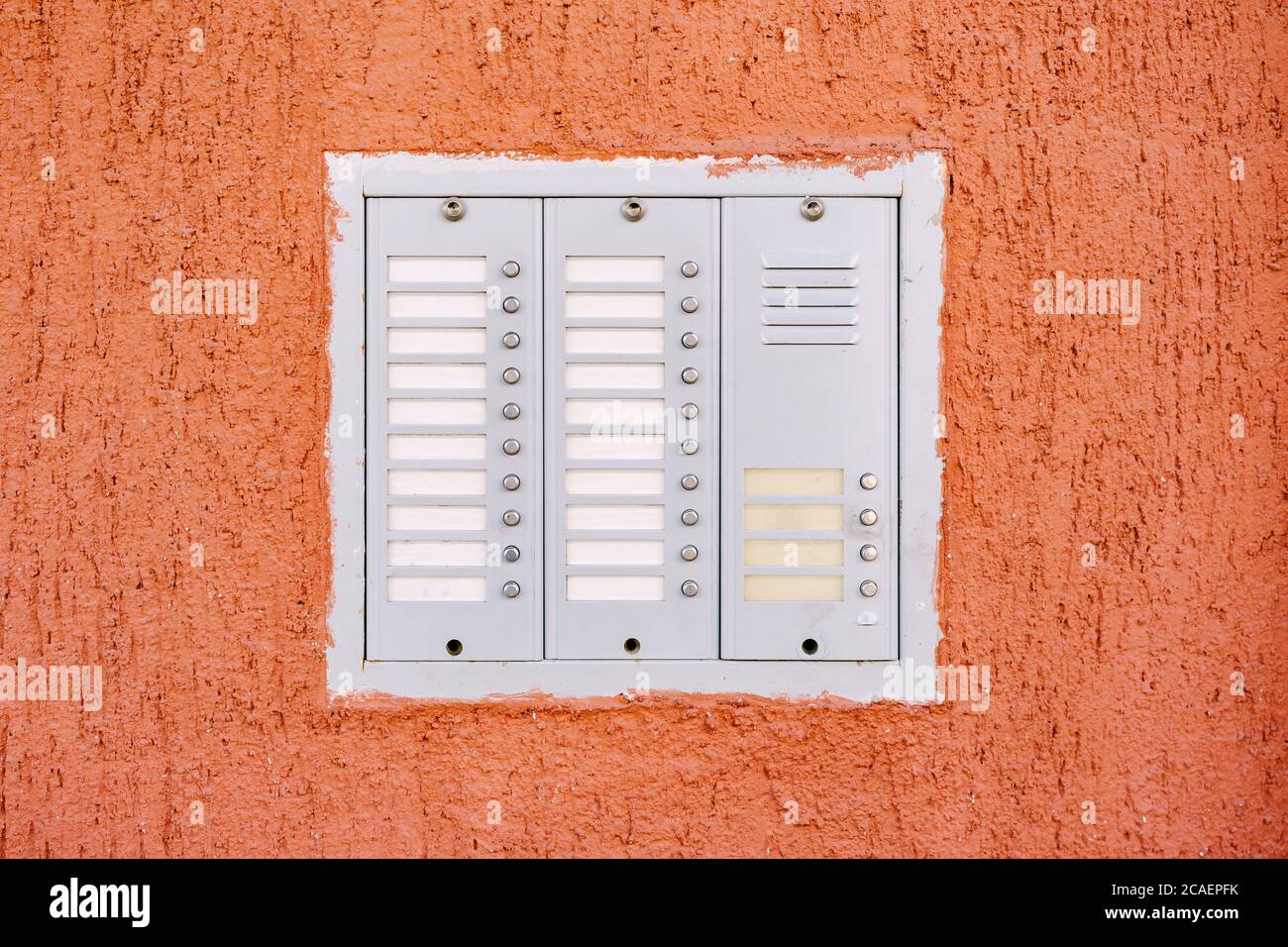 A gray intercom on an orange rough wall Stock Photo - Alamy