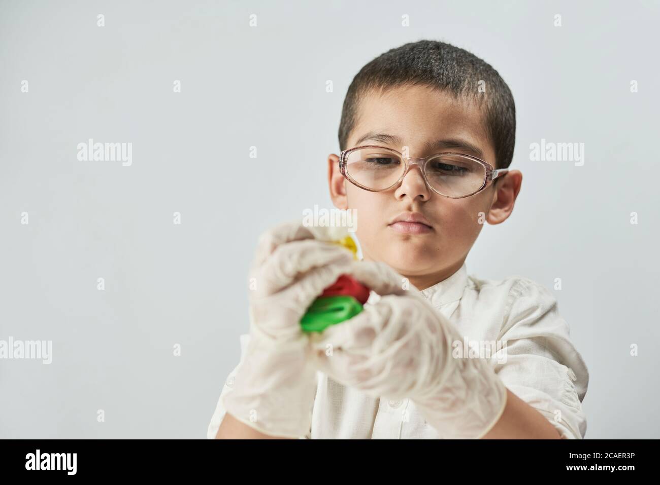 Little boy scientist in white making experiments against the white ...