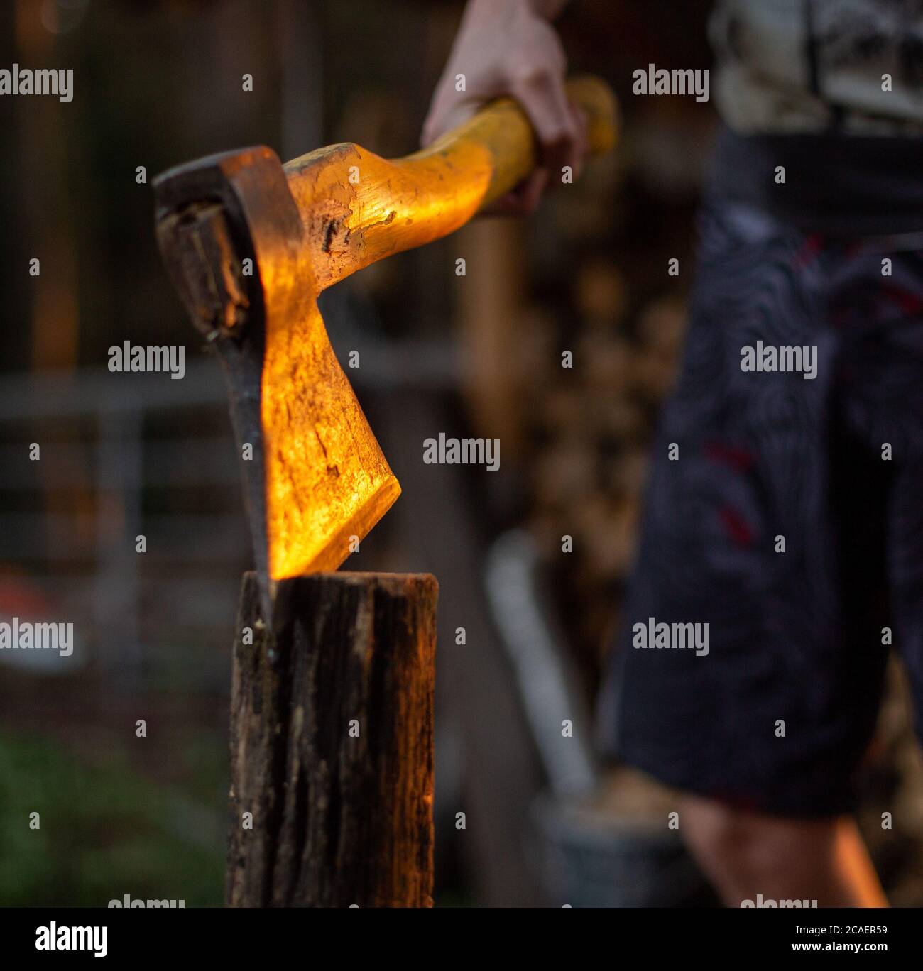 Man holding the sharp axe in the cut wood on the ground Stock Photo - Alamy