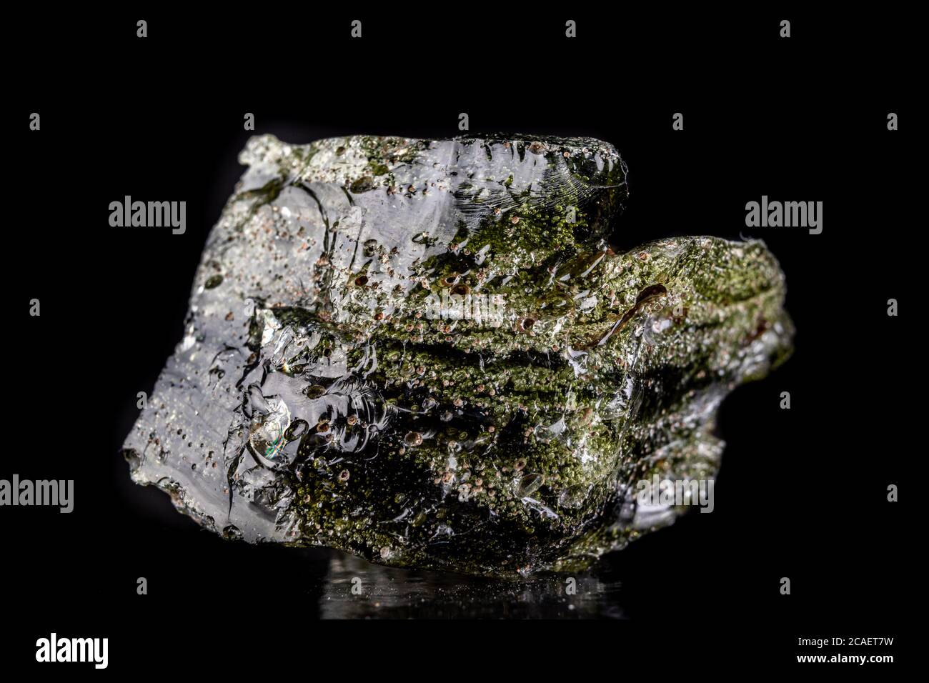 A piece of dark molten quartz with air bubbles. Melted sand in a glass ...
