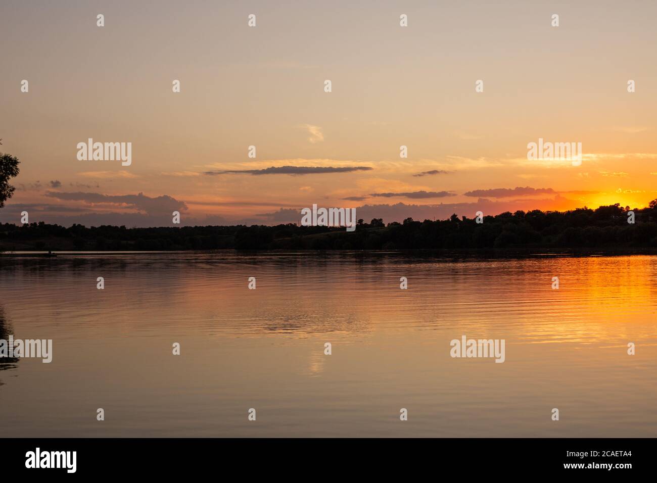 Lake gleaming under the beautiful, yellow sunset Stock Photo - Alamy