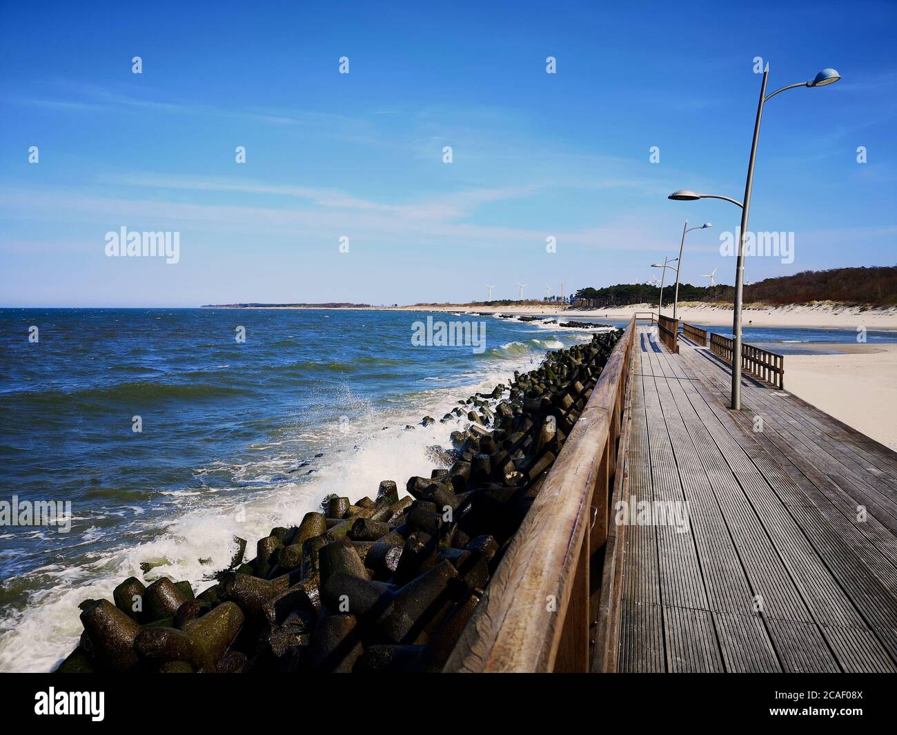 Tetrapod barrier and wooden boardwalk by a stretching coast of the ...