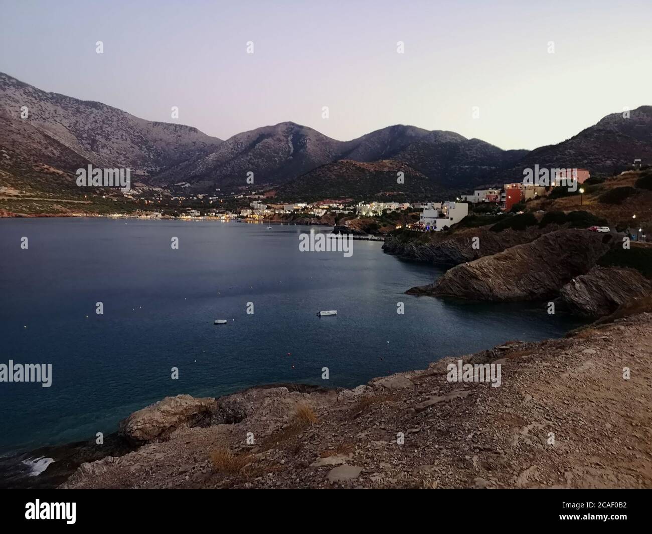 A mountainous chain disrupted by a stunning deep blue bay in Crete ...