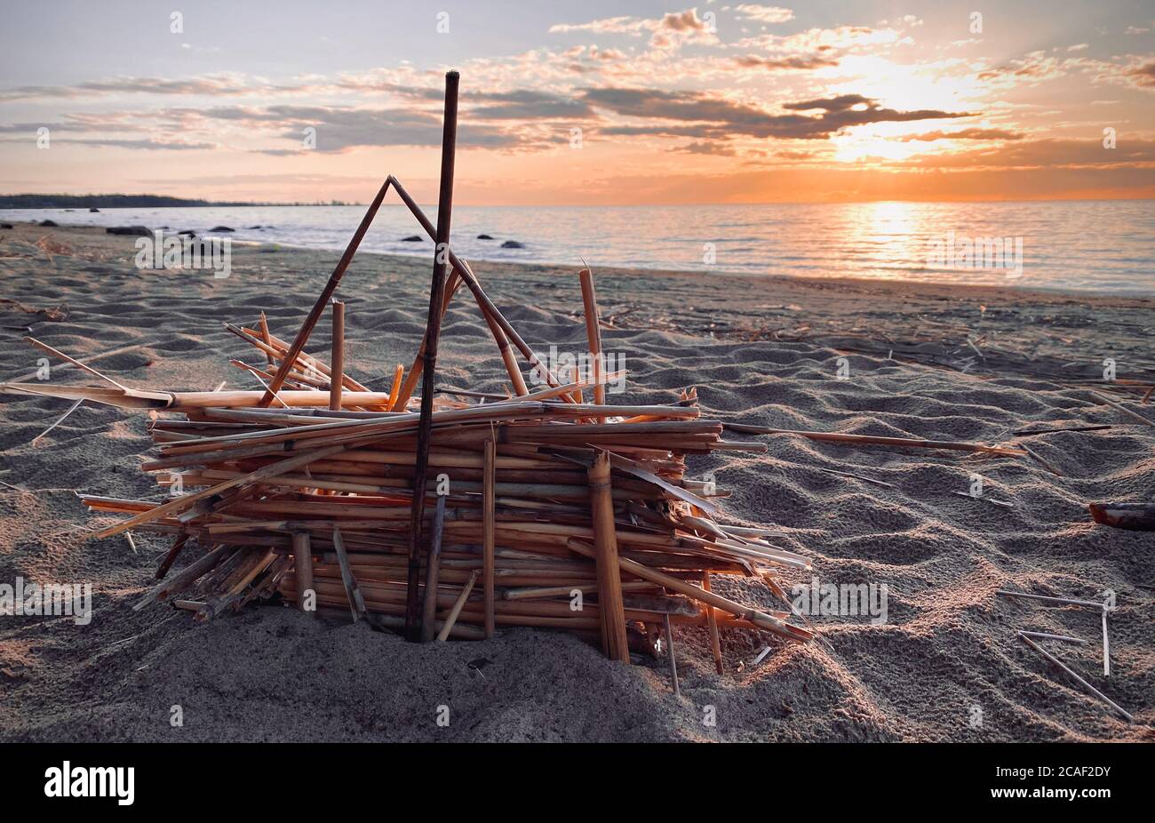 small hut made of straw on the sand by the sea at sunset Stock Photo ...