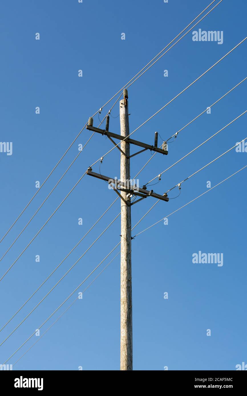 Wooden telephone pole and electrical lines with blue sky background ...