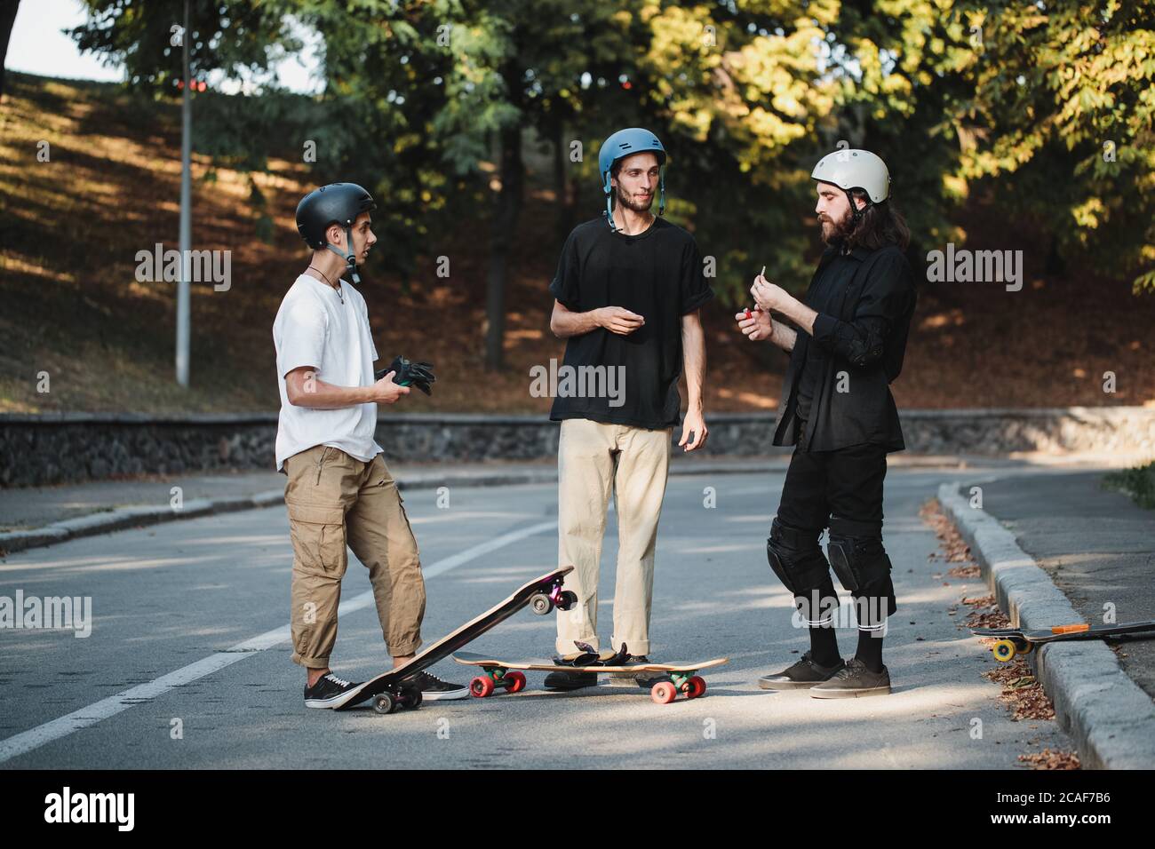 Three guys talk about skateboarding Stock Photo - Alamy