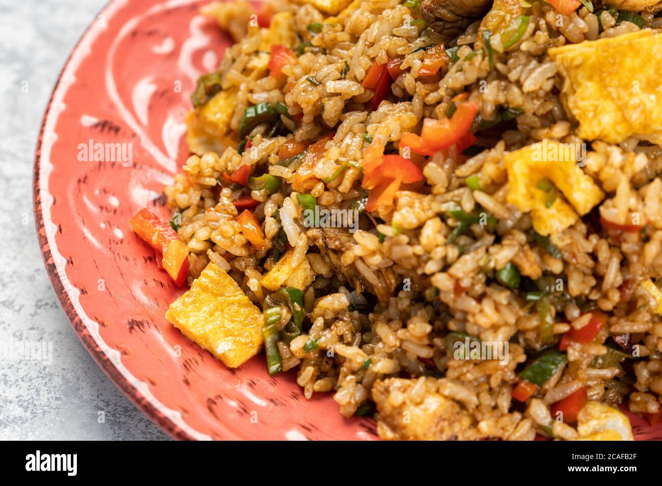 Closeup of delicious cooked rice with vegetables and sauce in a plate ...