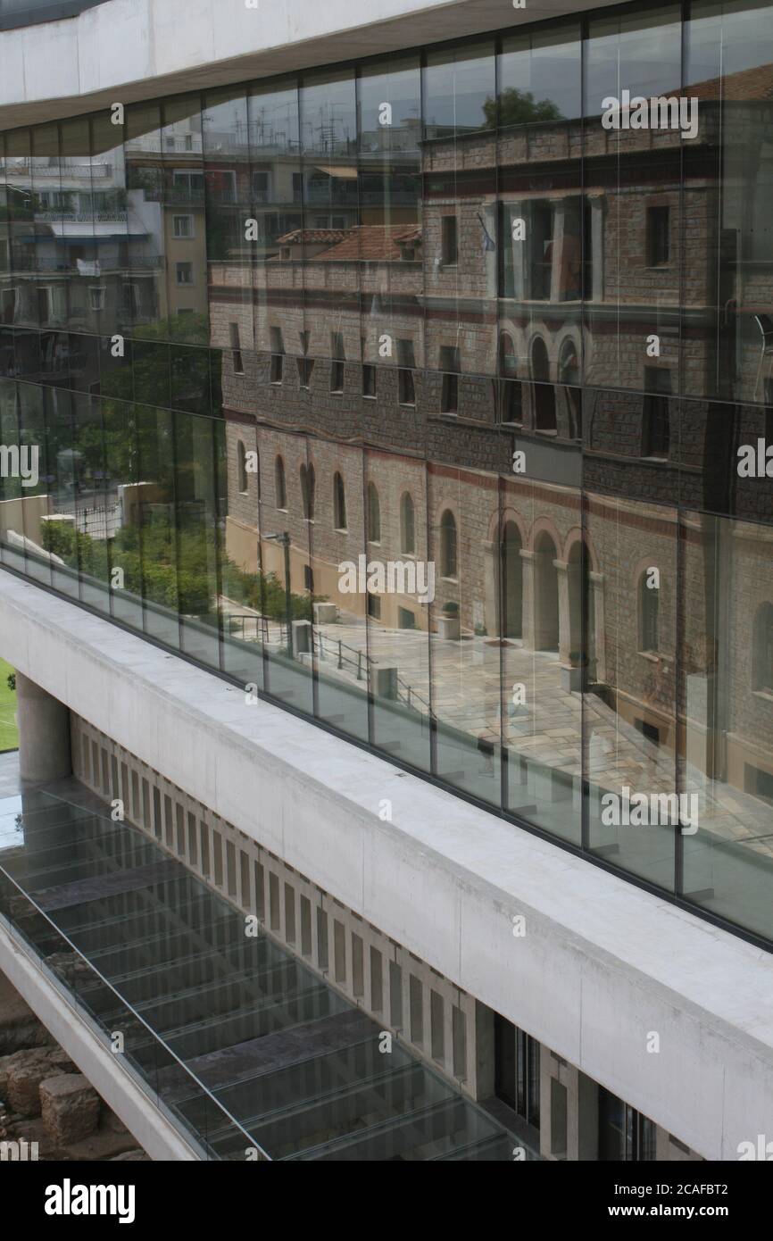 Vertical shot of modern glass building with a reflection of a brick ...