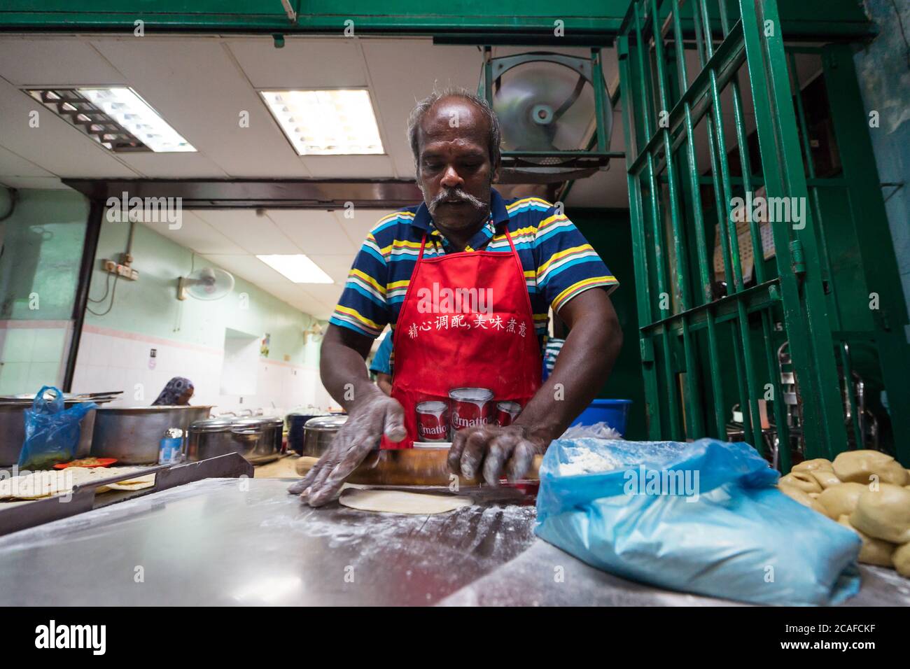 Georgetown / Malaysia - February 12, 2019: Indian man preparing chapati ...