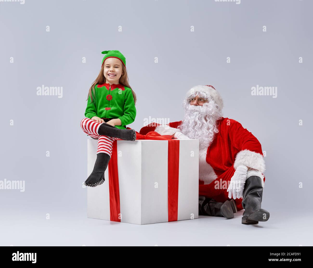 Jolly elf and Santa Claus play together Stock Photo - Alamy