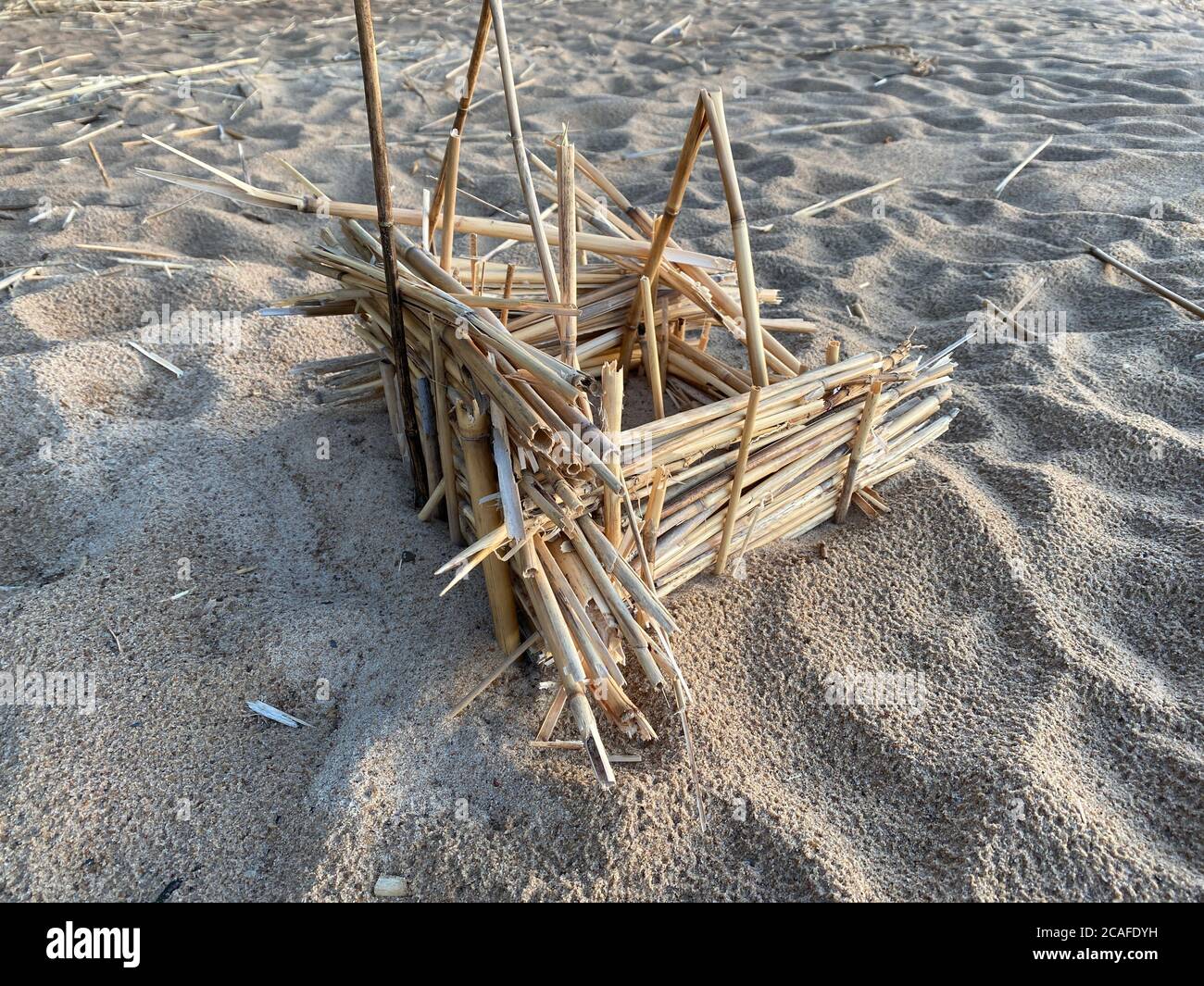 small hut made of straw on the sand by the sea at sunset Stock Photo ...