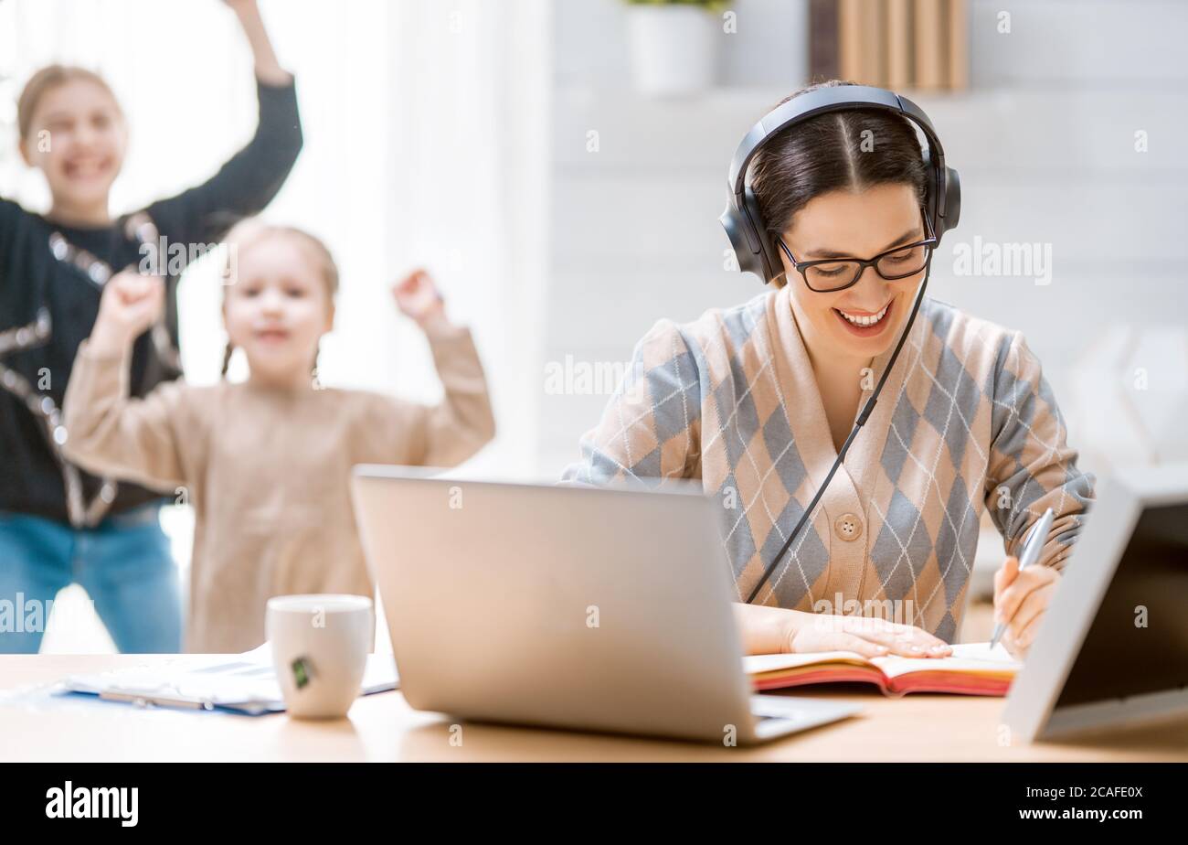 Young mother with children working on the computer. Family at home ...
