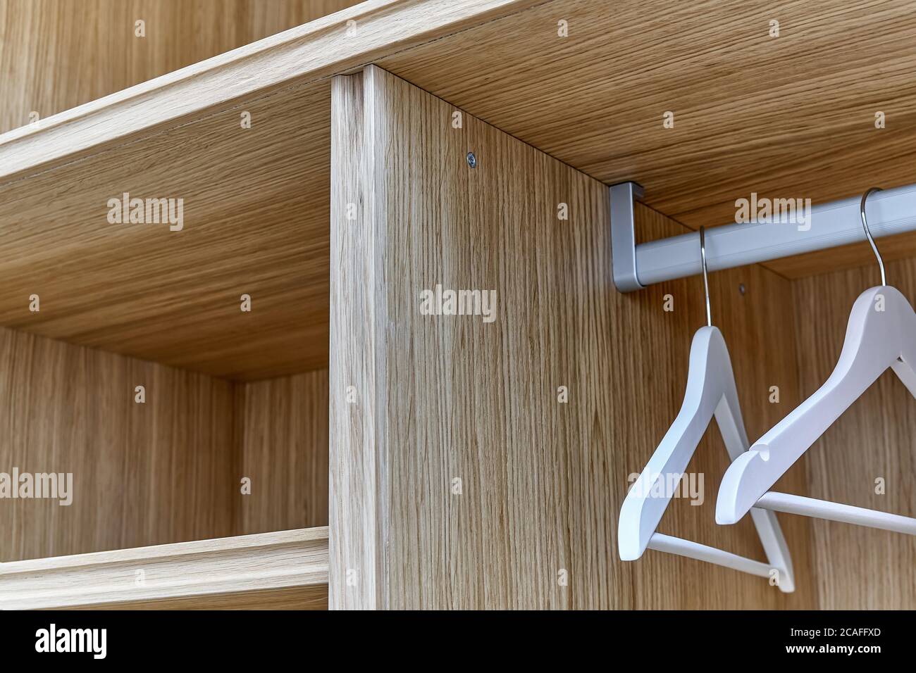Opened white wardrobe with wooden shelves. Wooden filling of wardrobe ...