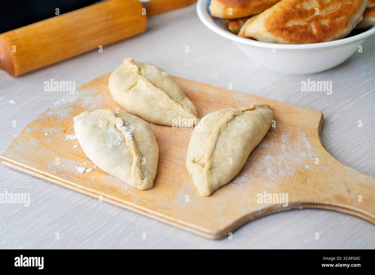 Not fried pies lie on wooden Board. Home cooking. Baking at home Stock ...