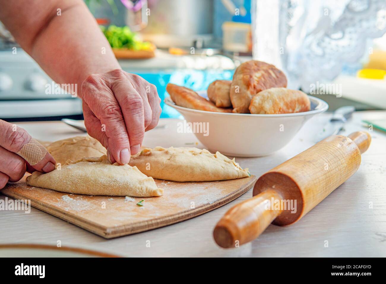 Grandma is in the kitchen baking pies. Female baker cooking bread ...