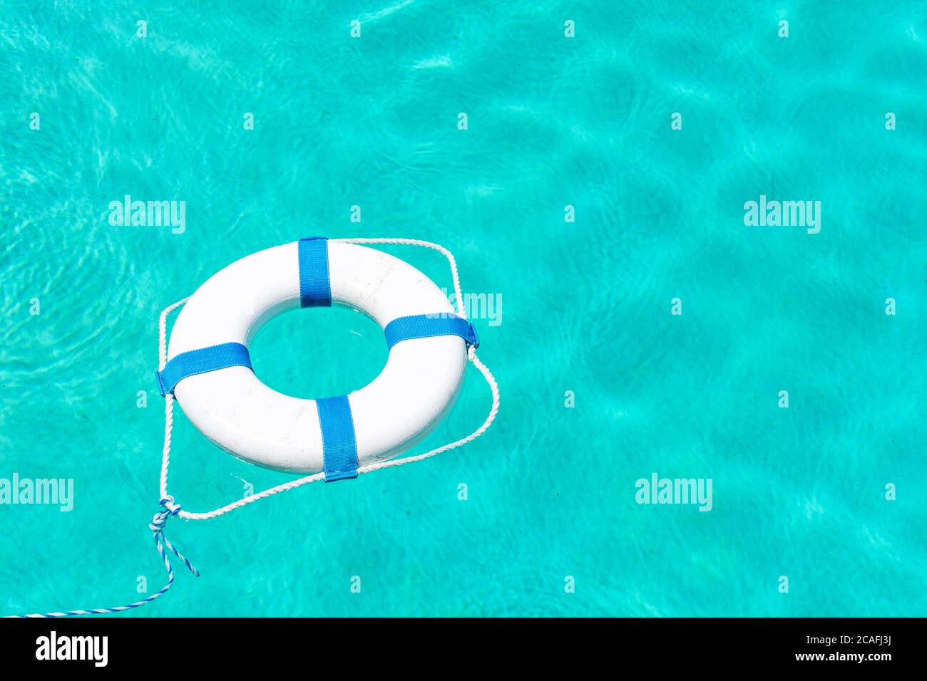 Foam ring pool buoy with nylon tow rope surround on swimming pool water ...