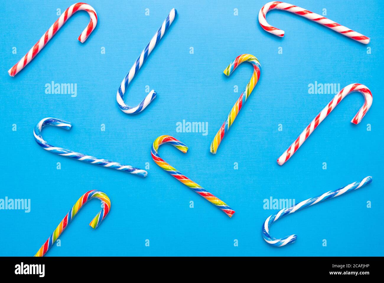 lot of multi-colored candy canes on a blue background, copy space Stock ...