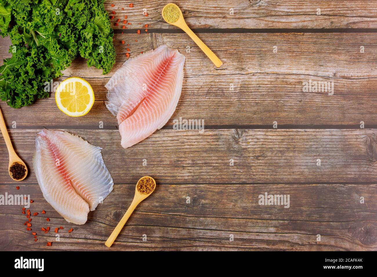 Organic fish tilapia on table with lemon and seasoning Stock Photo - Alamy