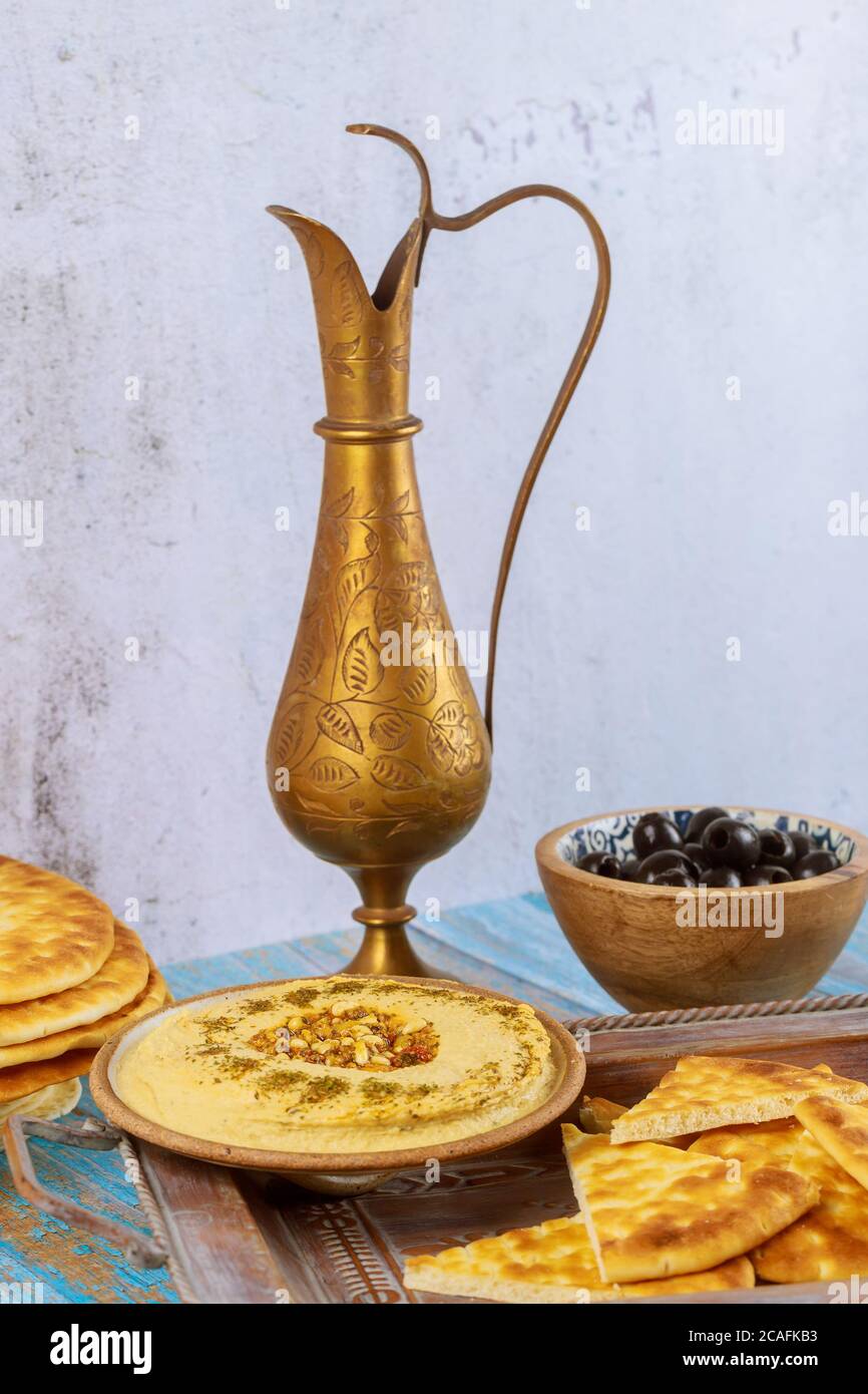 Turkish party table with hummus, bread, olives and copper jug Stock ...