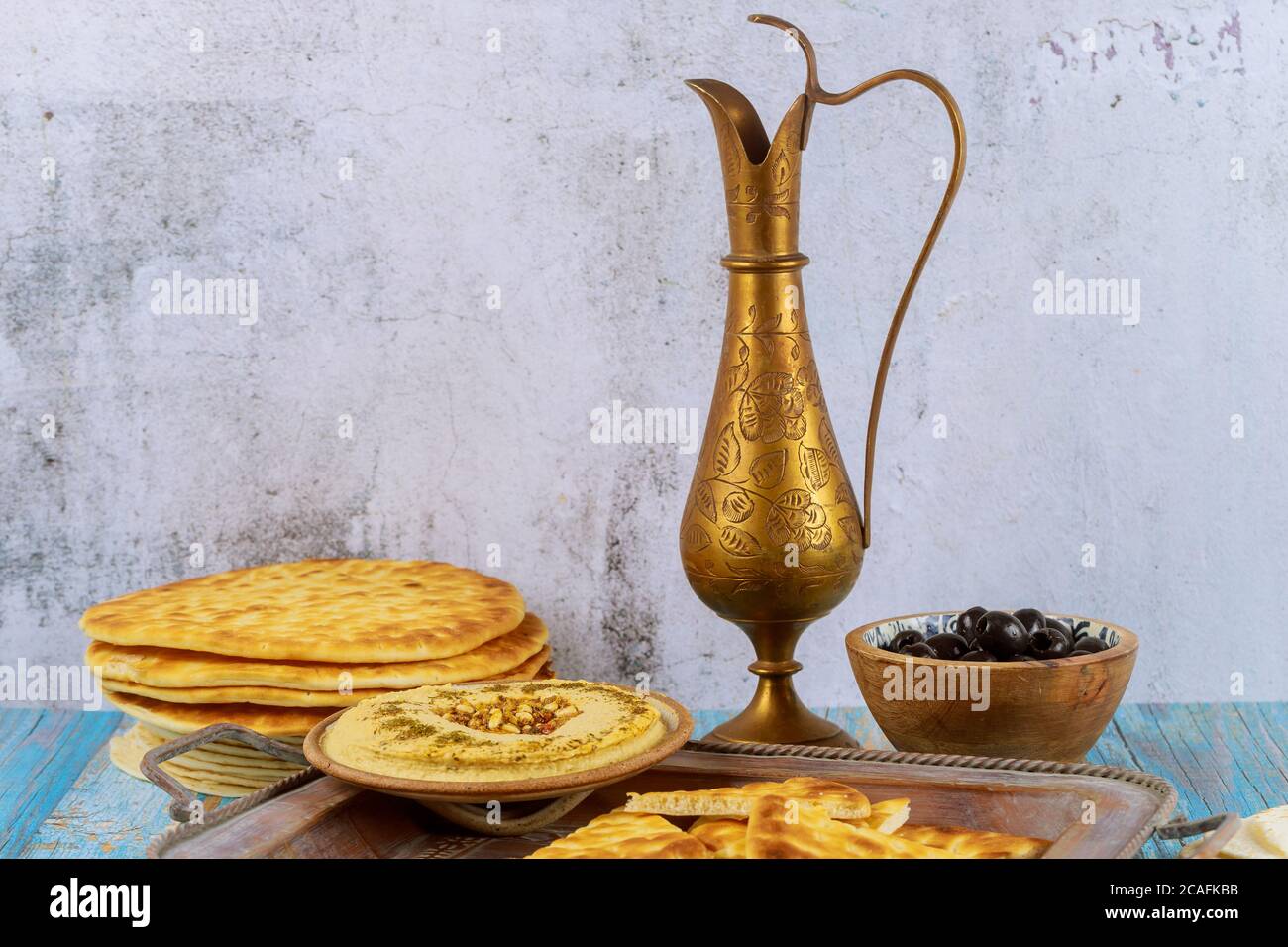 Lebanese party table with hummus, bread, olives and copper jug Stock ...
