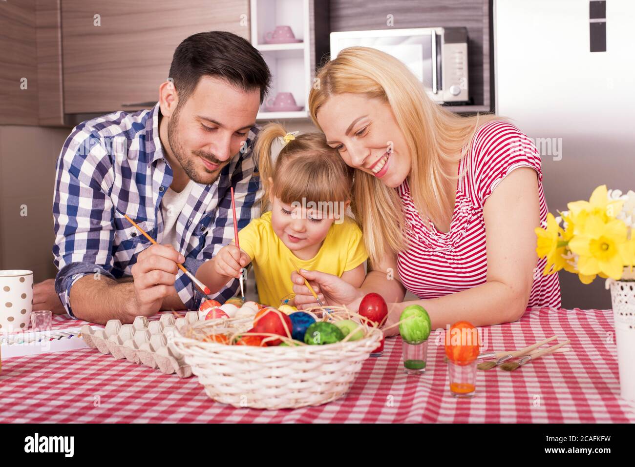 Beautiful family painting the easter eggs with their child Stock Photo ...
