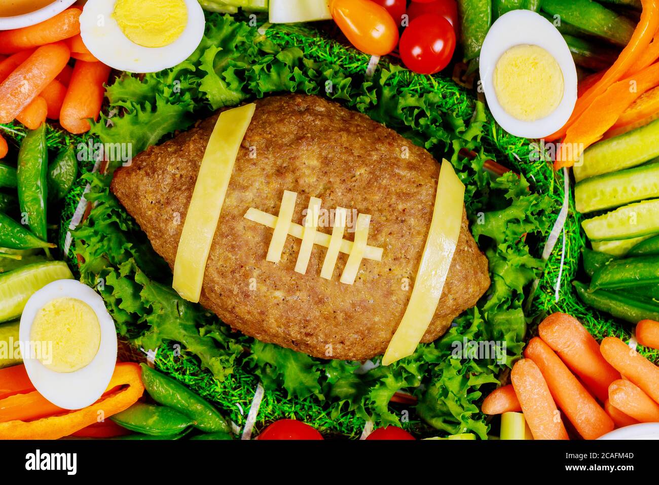 Colorful vegetable platter with egg and meatloaf like a football ball ...
