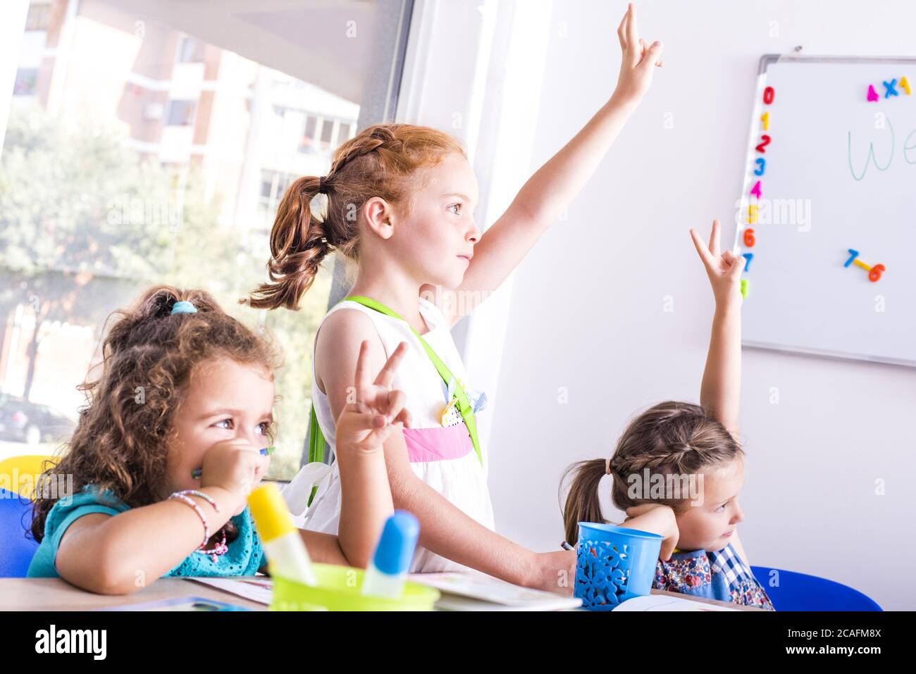 Group of happy little school kids in the classroom Stock Photo - Alamy