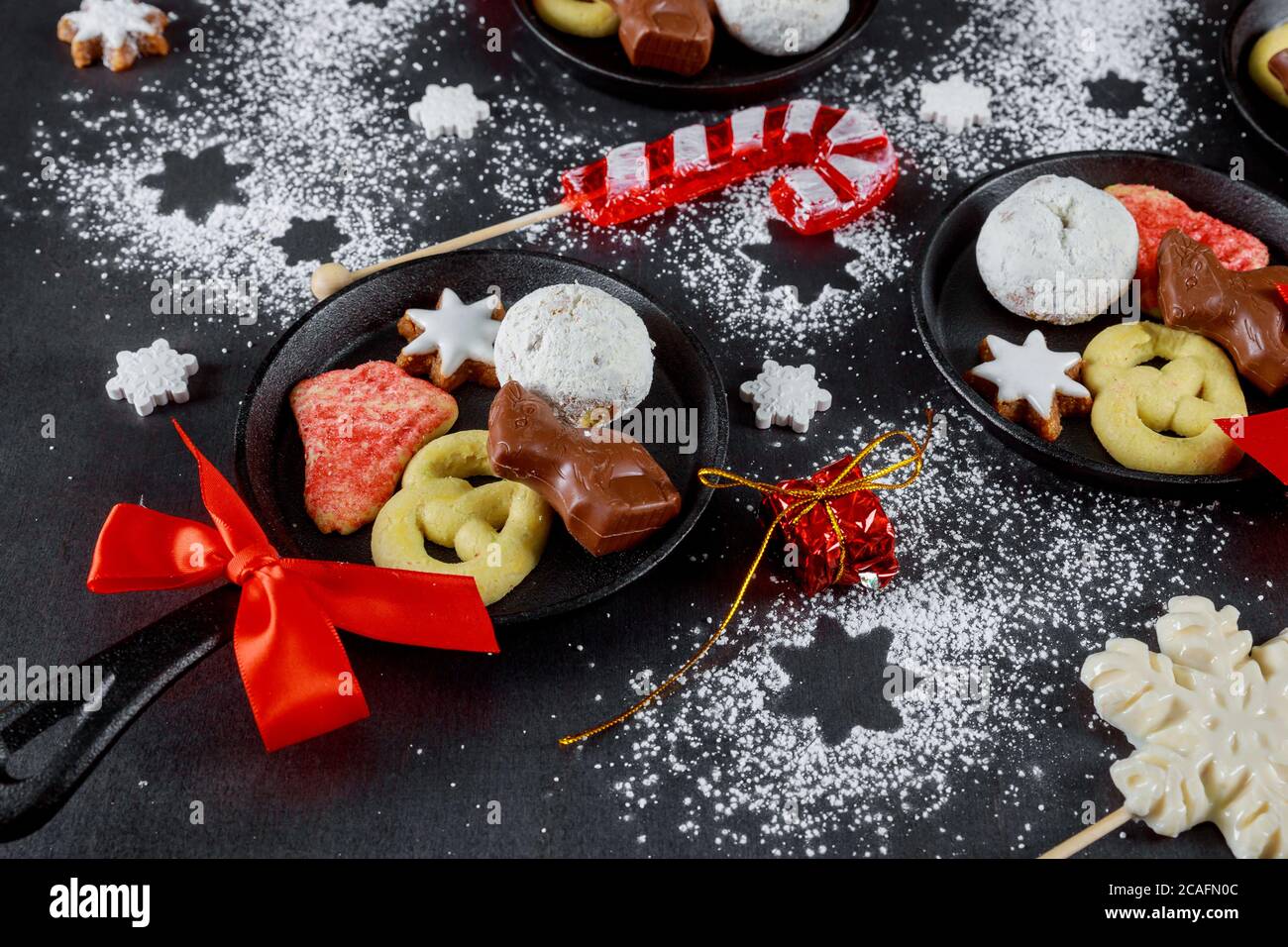 Top view of mini iron skillets with sweets. Christmas cookie, chocolate ...