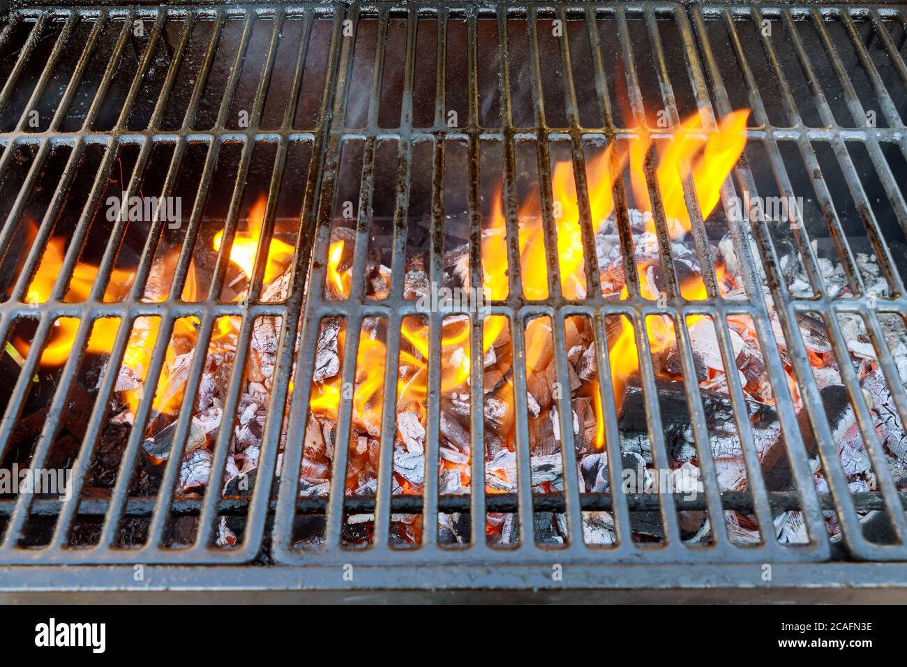 Flames goes through grid of barbecue grill with charcoal Stock Photo ...