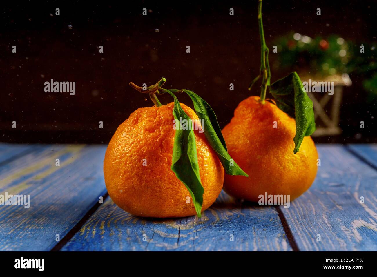 Two tangerines with green leaf on wooden table Stock Photo - Alamy
