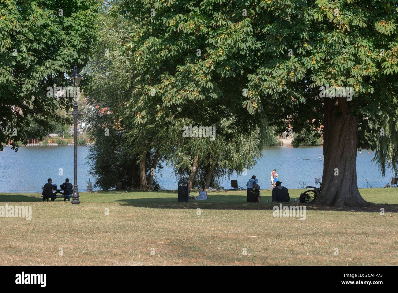 Park people summer, view in summer of people relaxing beside the mere ...