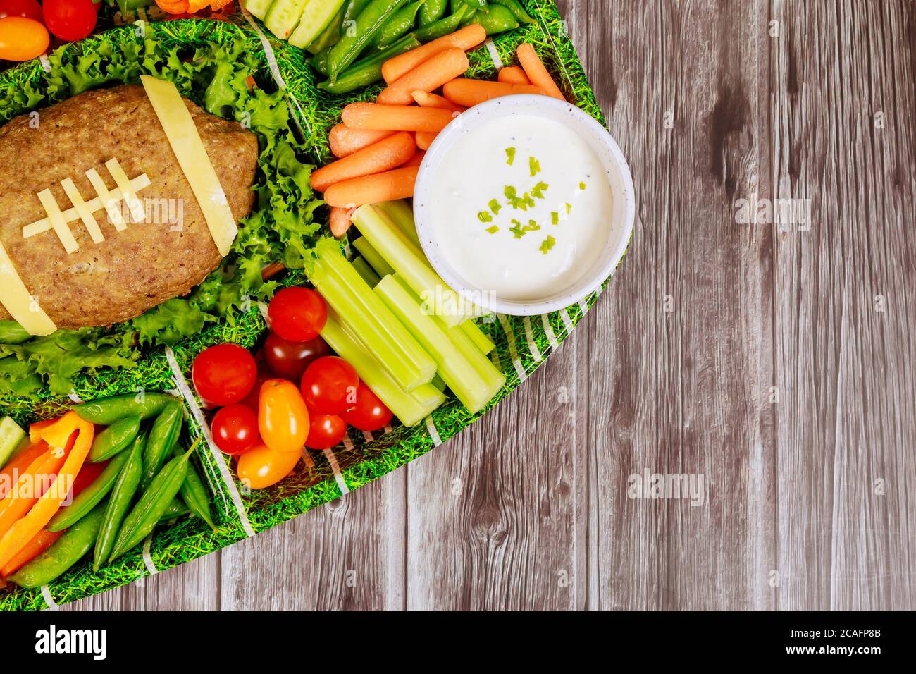 Colorful vegetable platter with meatloaf like a football ball and ...