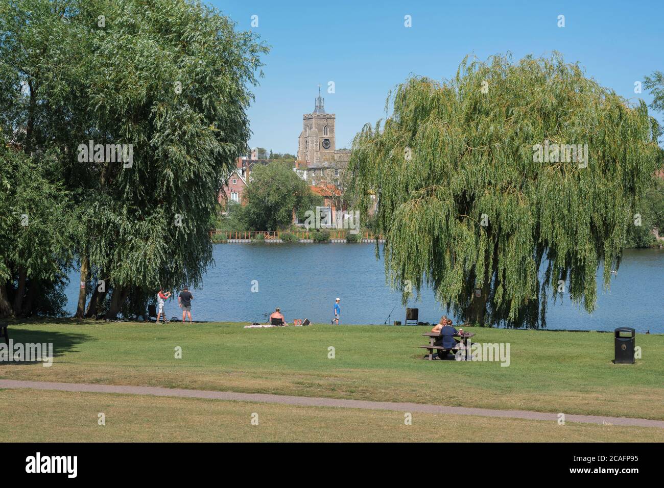Diss Mere, view in summer of people relaxing beside Diss Mere with the ...