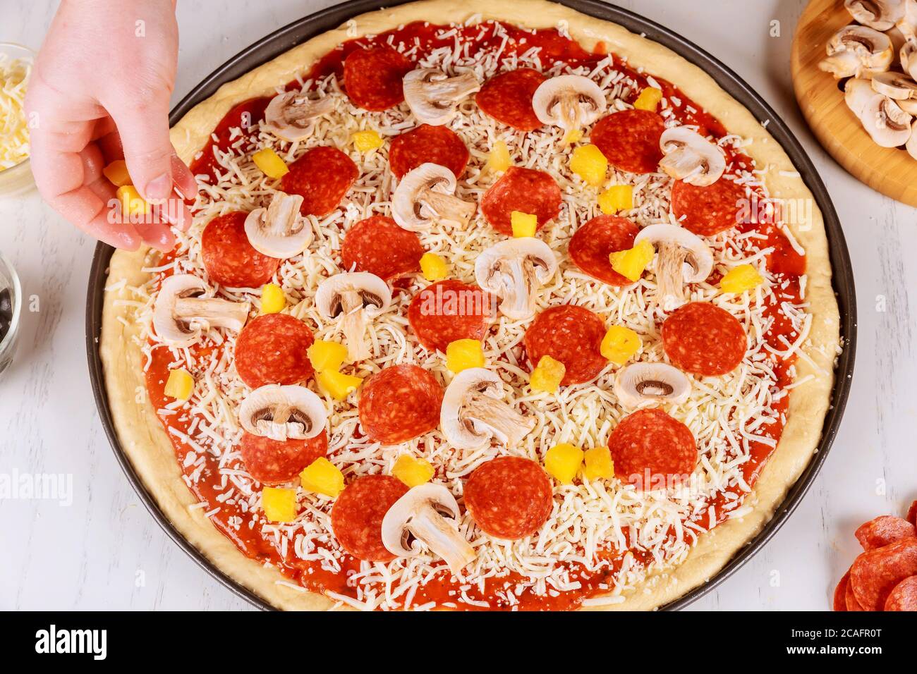 Chef putting pepperoni on pizza hi-res stock photography and images - Alamy