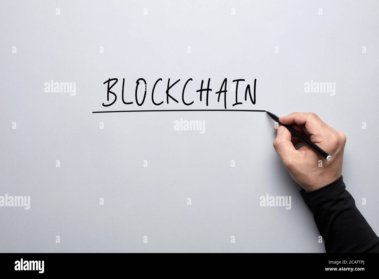 The word blockchain handwritten and highlighted with a male hand on ...