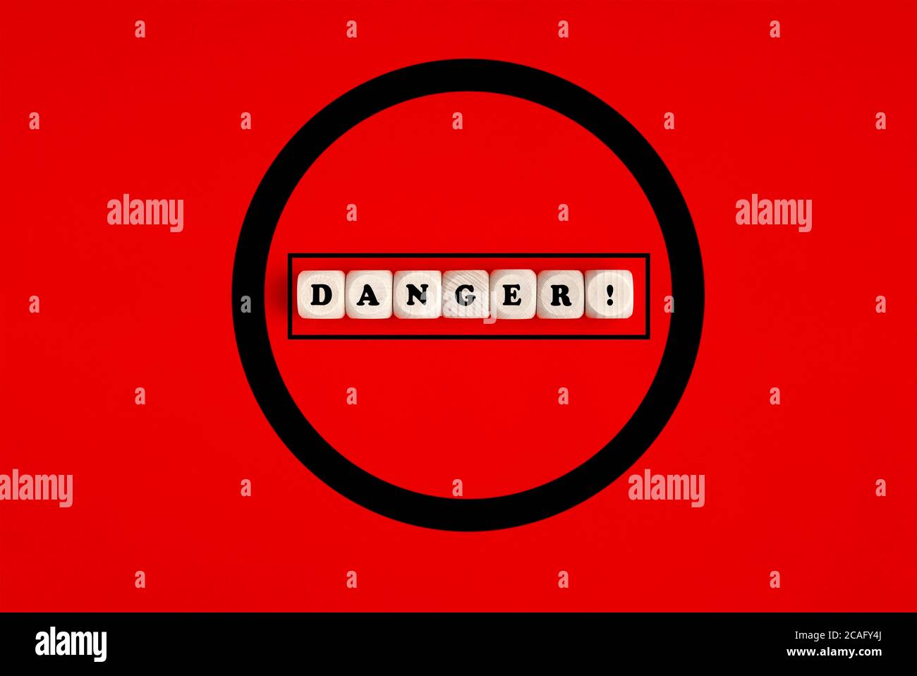The word danger written on wooden cubes with a sign on red background ...